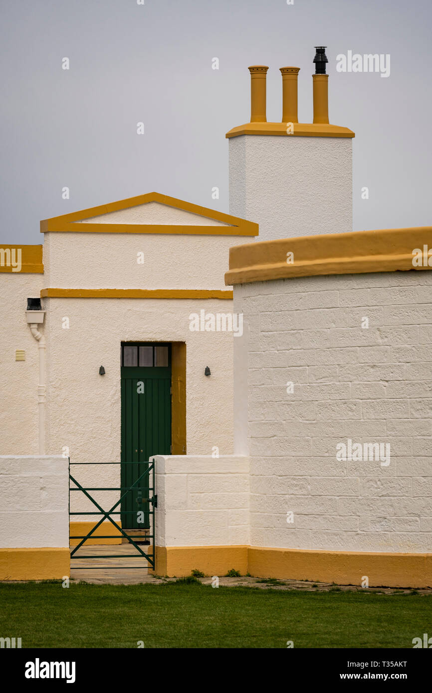 The white and yellow painted masonry buildings located around the base ...
