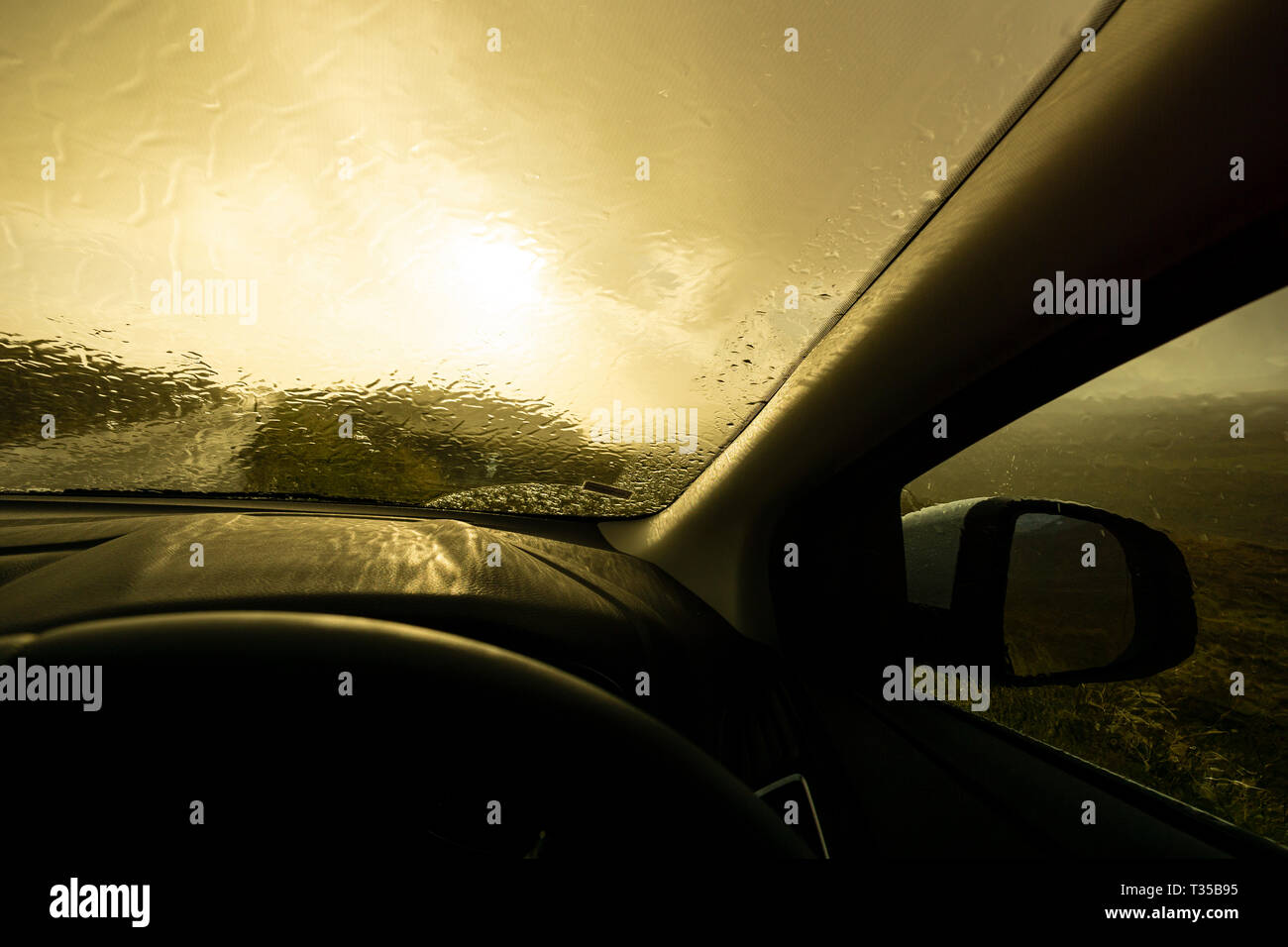 The sun breaks through the clouds as seen through the rain-splattered ...