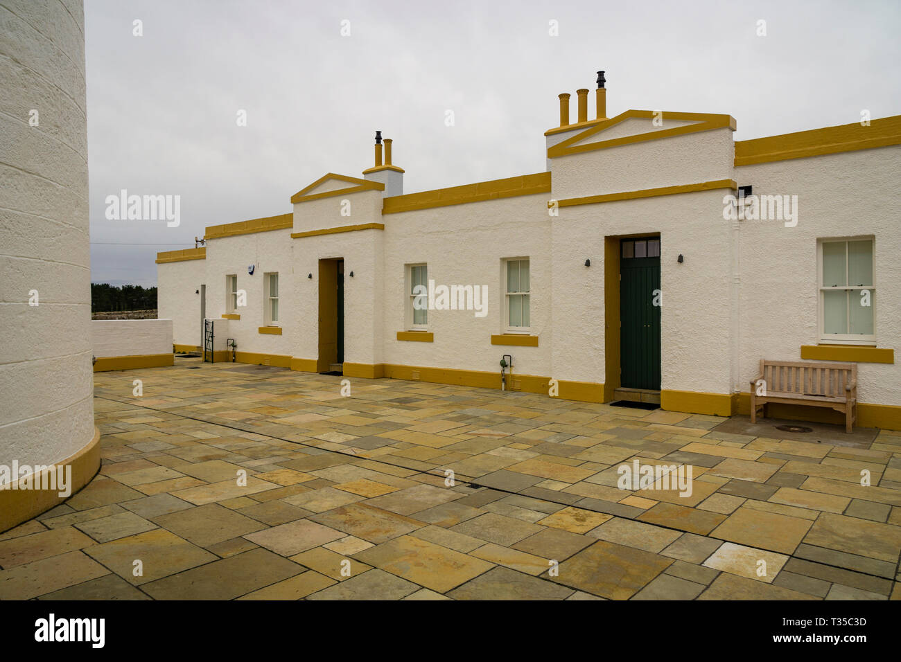 The white and yellow painted masonry buildings located around the base ...