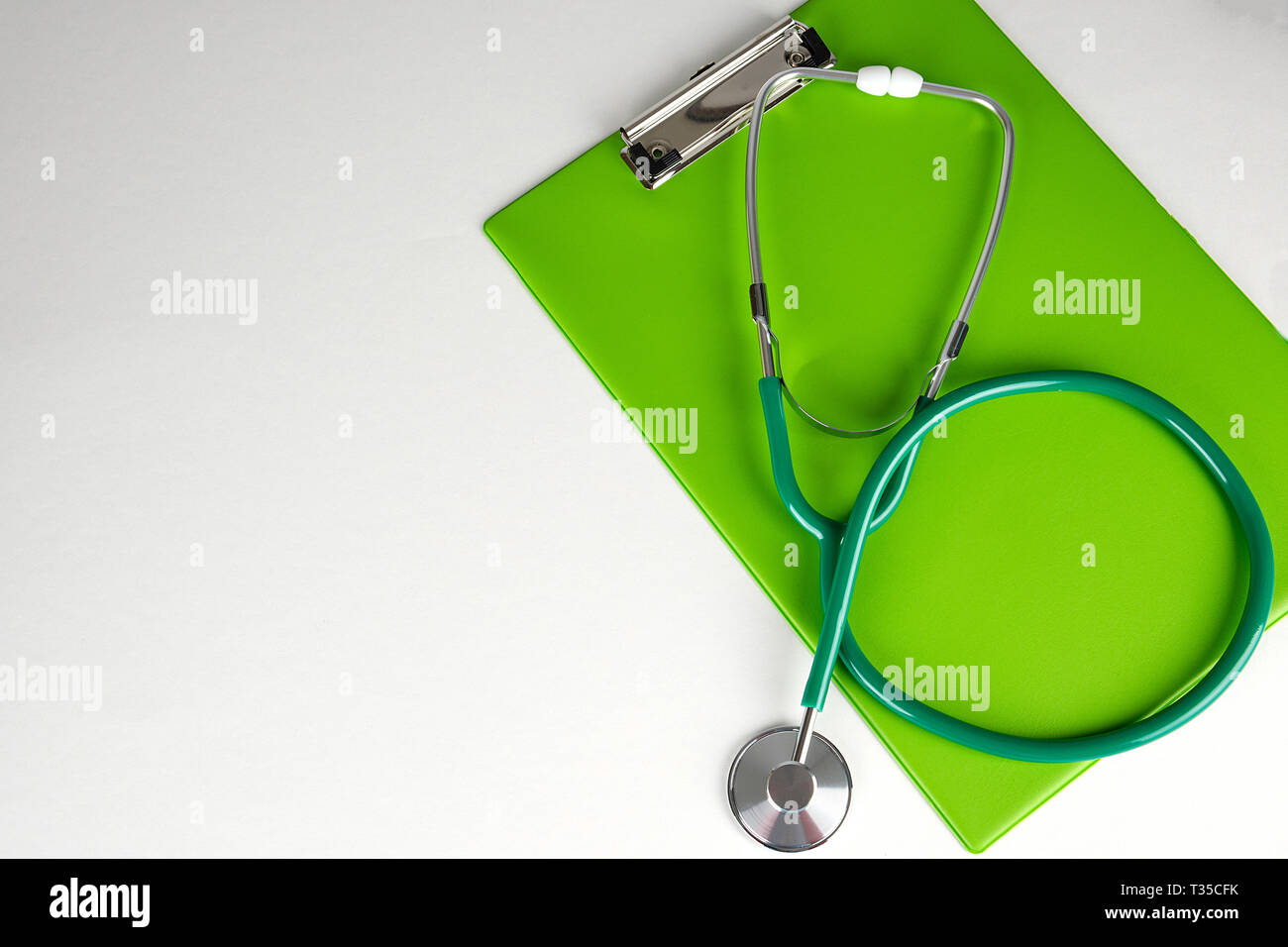 medical stethoscope and green paper holder on a white background, copy ...