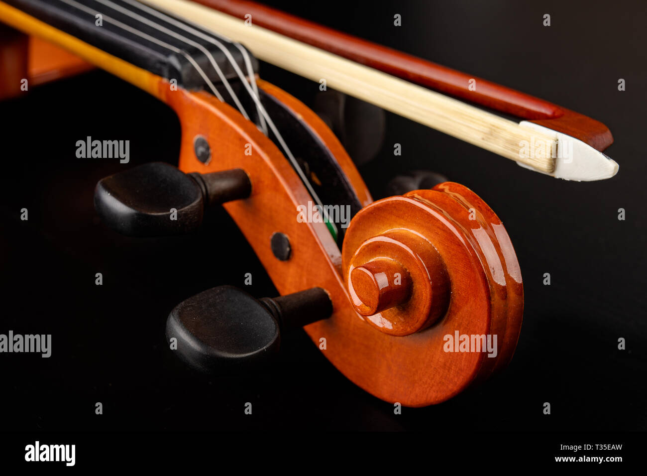 Beautiful new shiny violin on a dark table. Musical string instrument ...