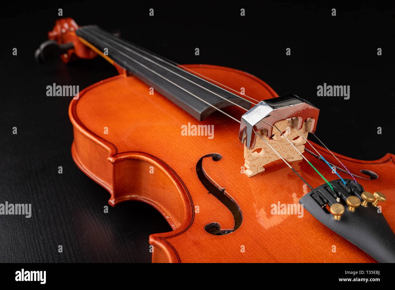 Beautiful new shiny violin on a dark table. Musical string instrument ...