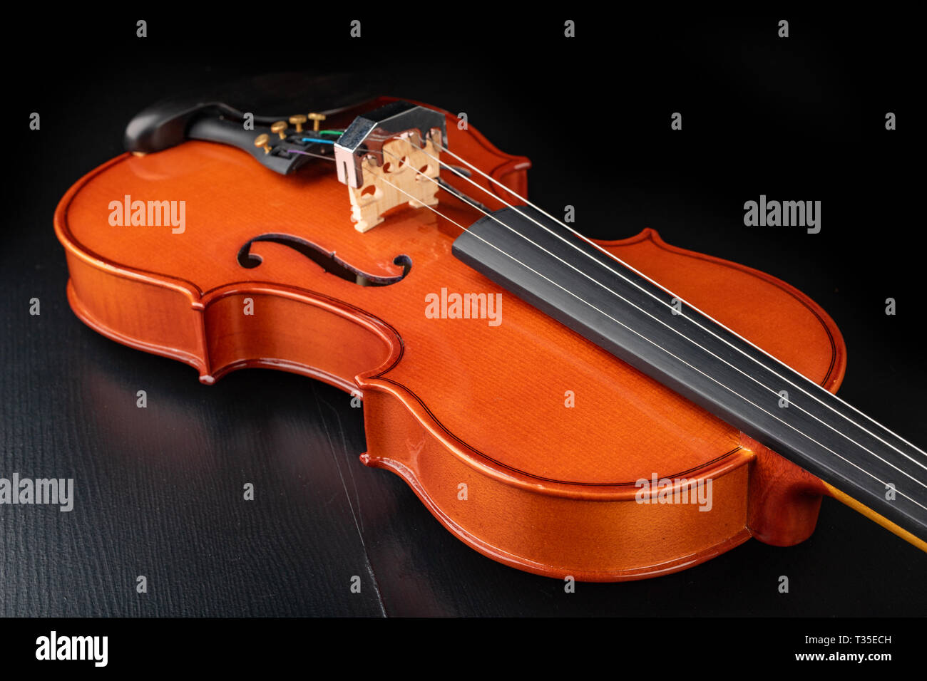 Beautiful new shiny violin on a dark table. Musical string instrument ...