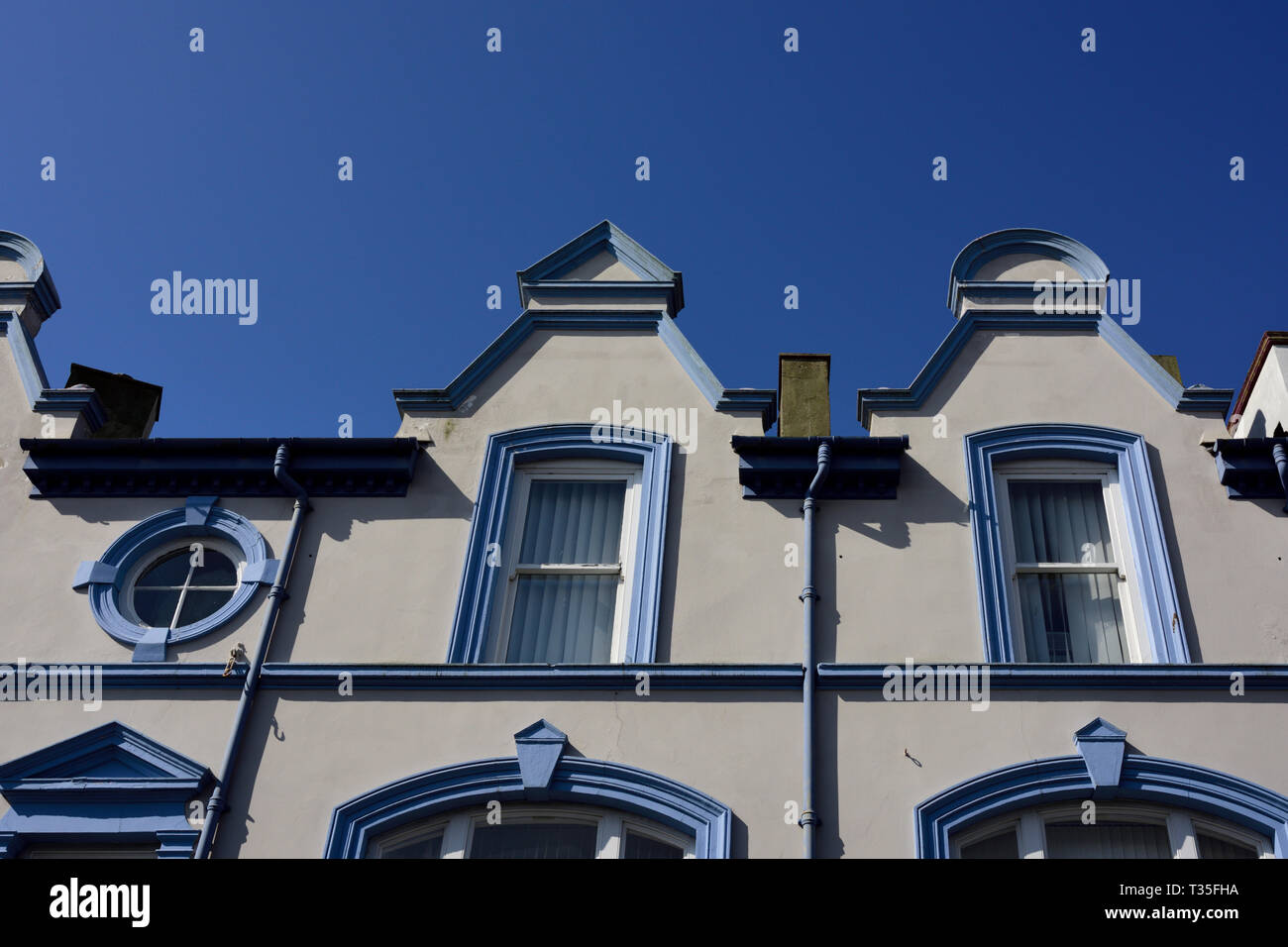 White rendered harbour building facade with pale blue painted window ...