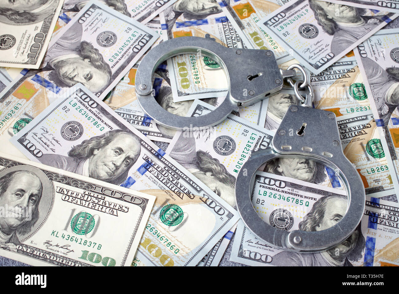Handcuffs on dollars background. Criminal money concept Stock Photo - Alamy