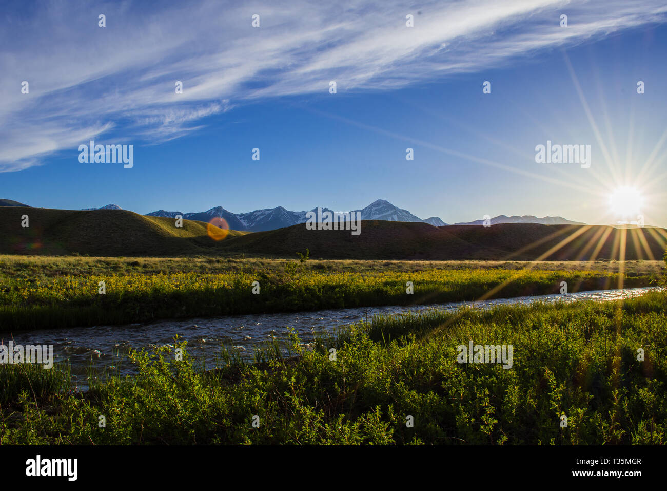sunburst over scenic stream Stock Photo - Alamy