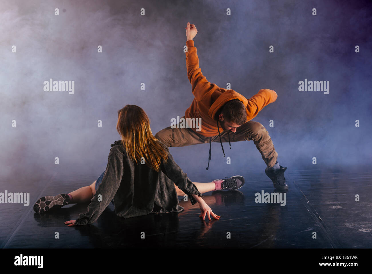 The beautiful female dancer is laying on the floor while her male ...