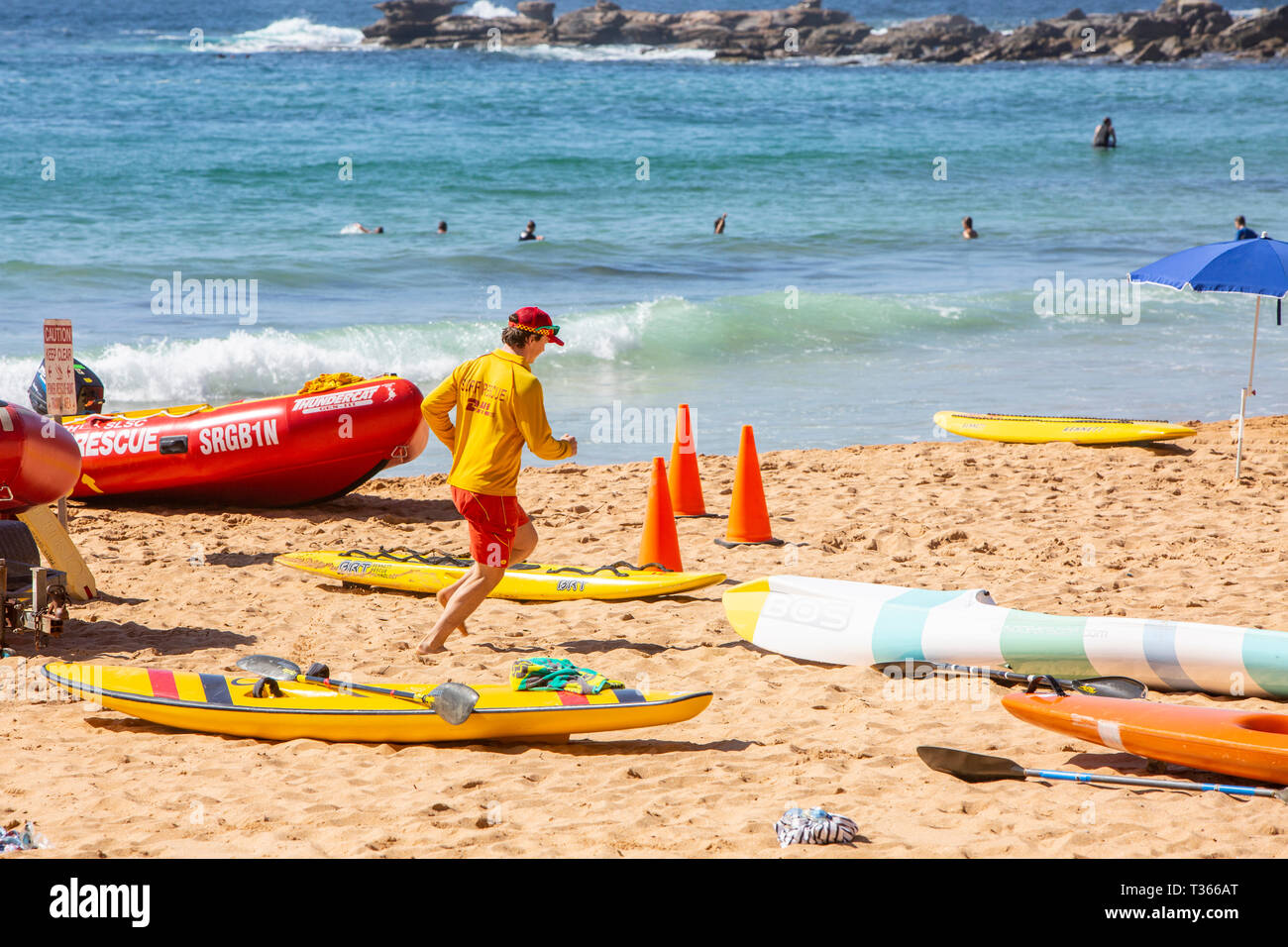 Surf rescue volunteer with surf rescue dinghy and surfboards on Palm ...
