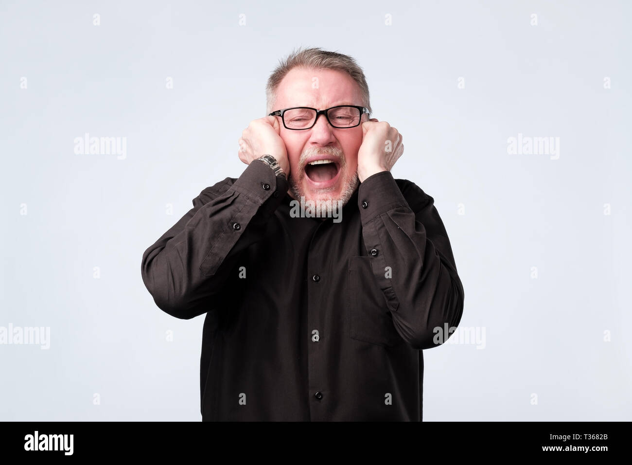 Covering his ears with hands ignoring hi-res stock photography and ...