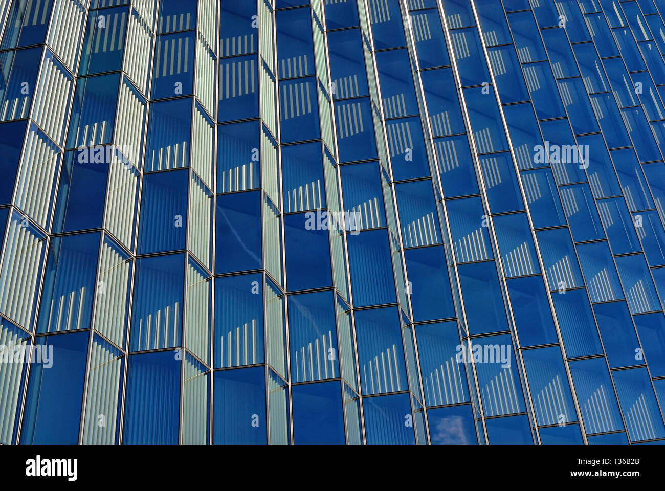 Pattern of the tall glass window structures scaling up the side of a ...