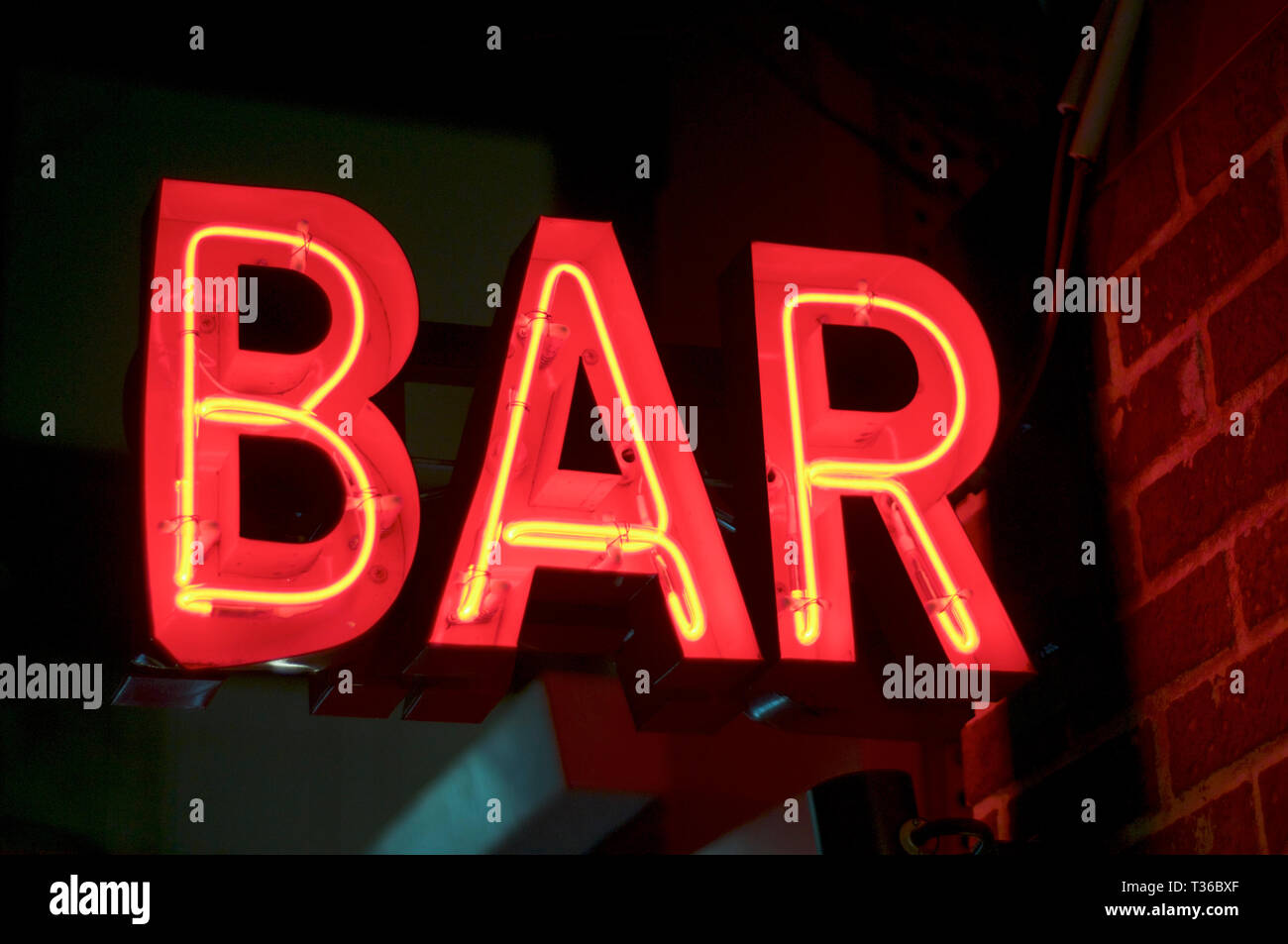 Neon red illuminated BAR sign captured with some color reflection on a ...