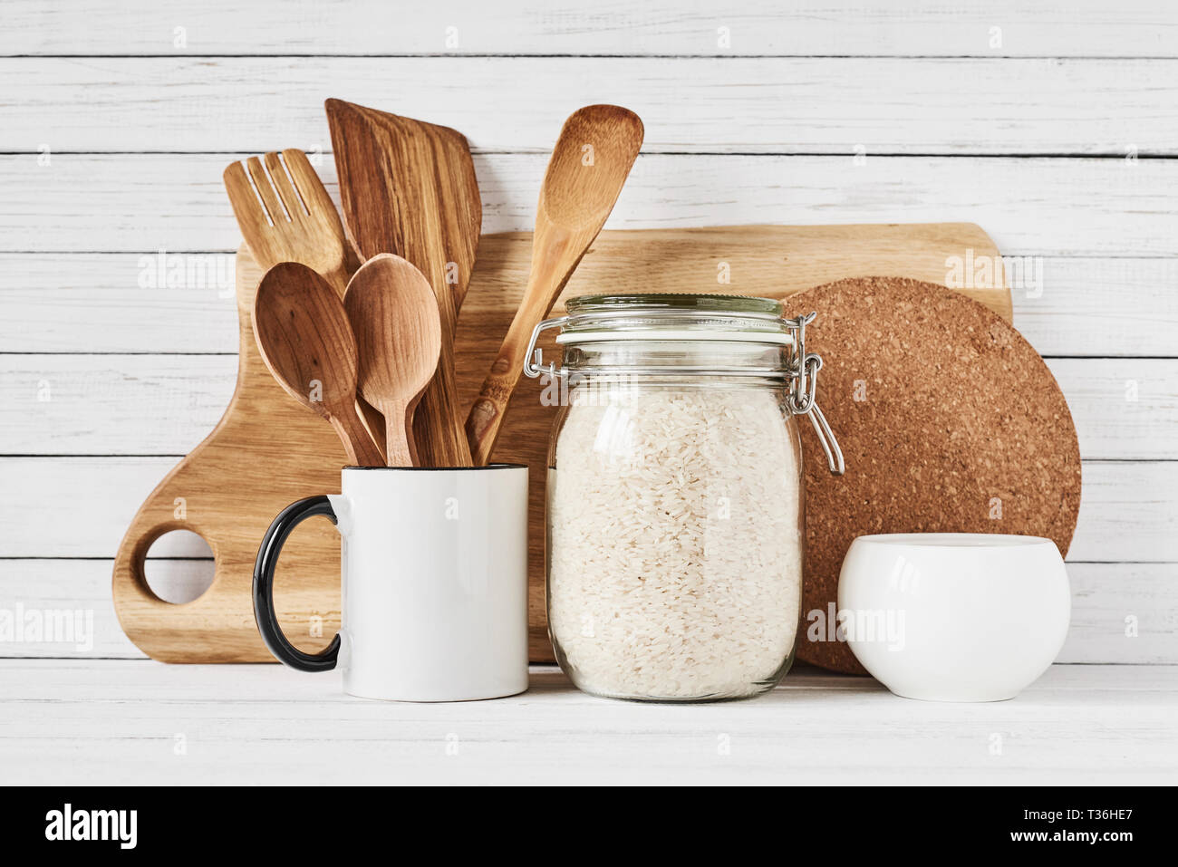 Kitchen tools and cutting board on white table, front view. Kitchen ...