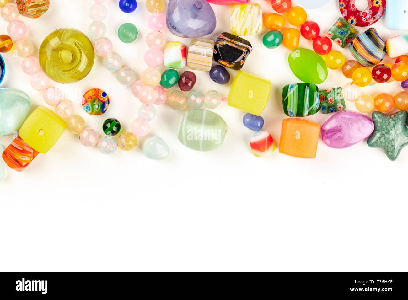 Many different beads, shot from above on a white background with a ...