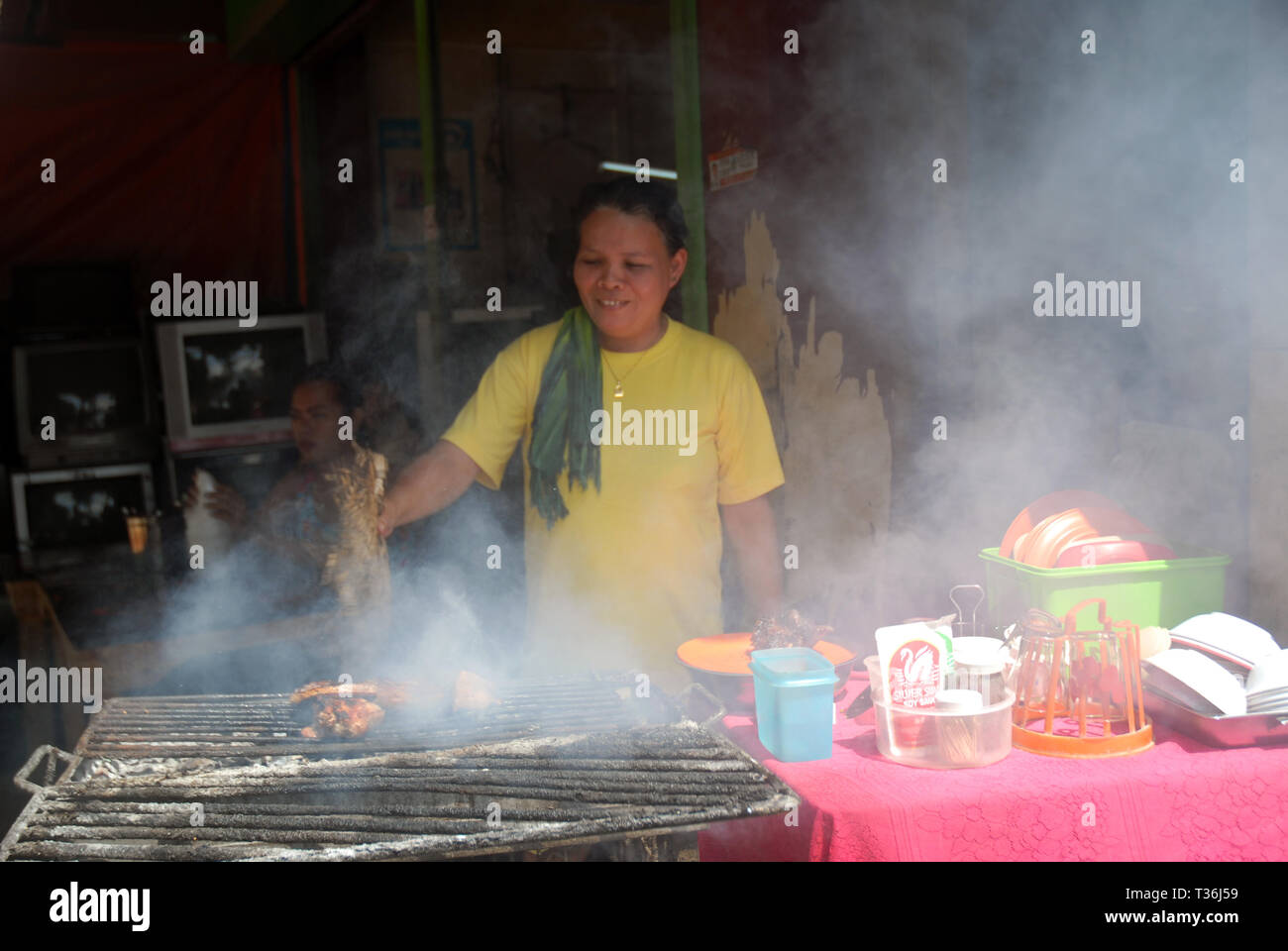Lady cooking meat to sell at food stall, Samal, Philippines Stock Photo ...