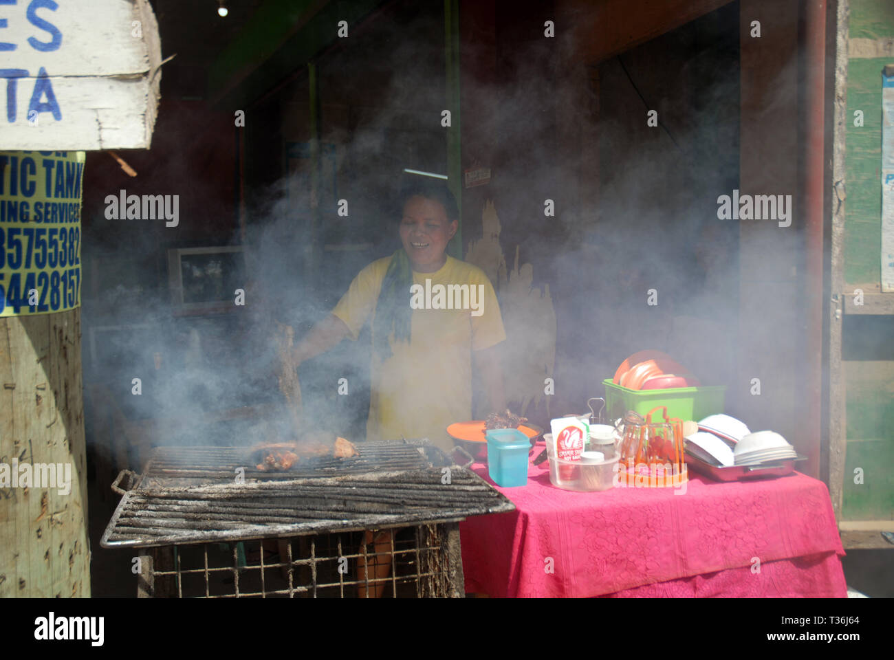 Lady cooking meat to sell at food stall, Samal, Philippines Stock Photo ...