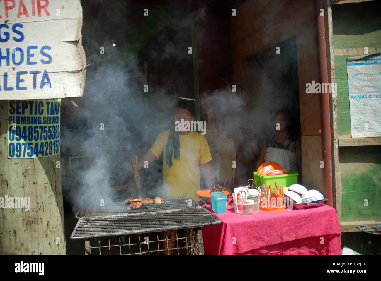 Lady cooking meat to sell at food stall, Samal, Philippines Stock Photo ...