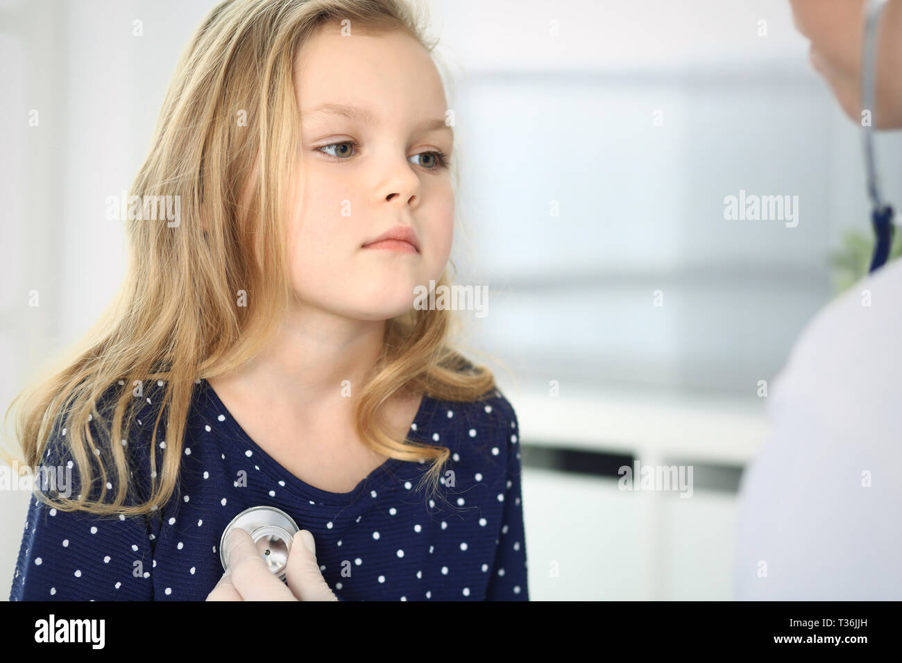 Doctor examining a child patient by stethoscope. Cute baby girl at ...