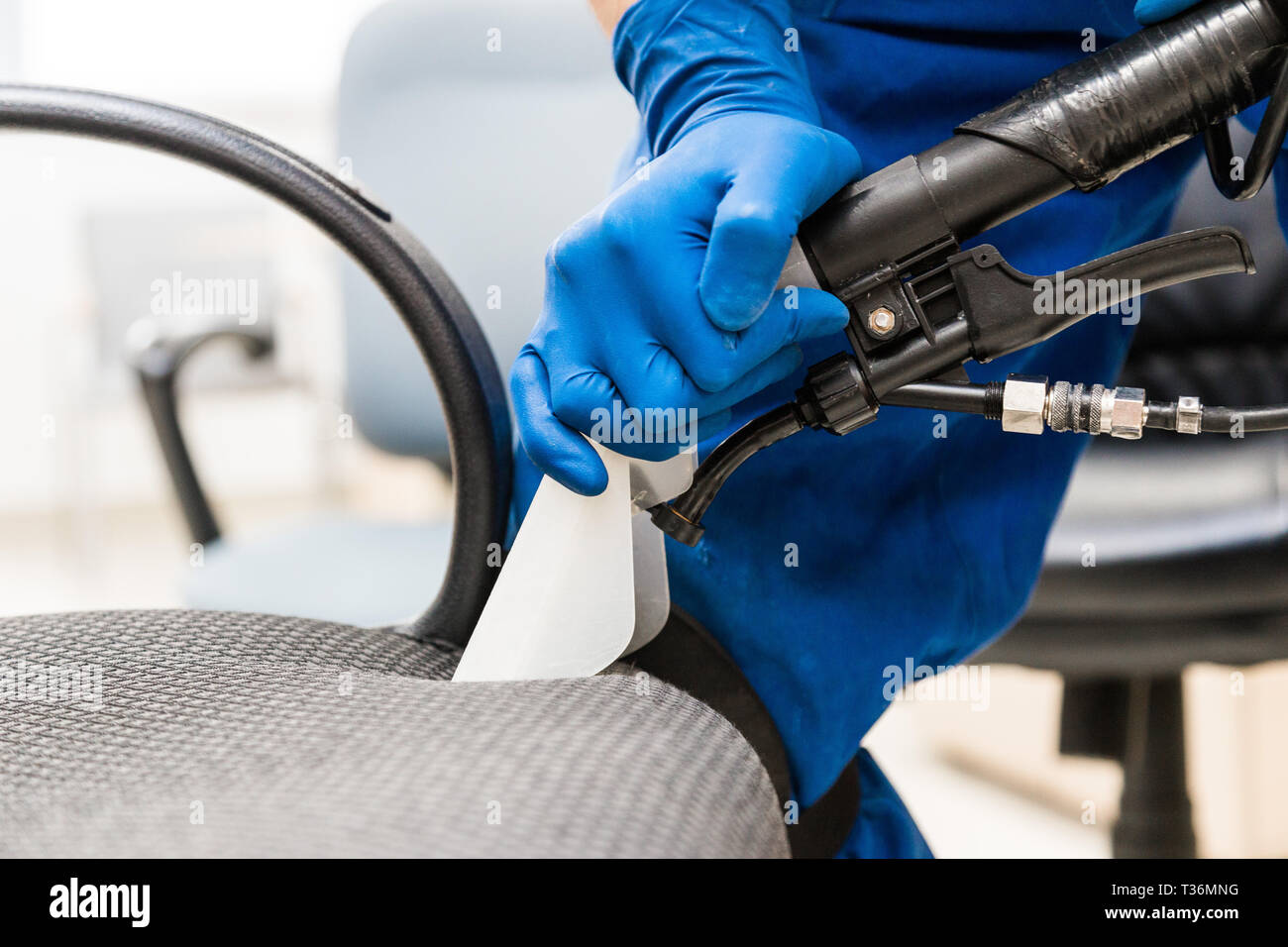 Cleaning service. Young man in workwear and rubber gloves cleans the ...