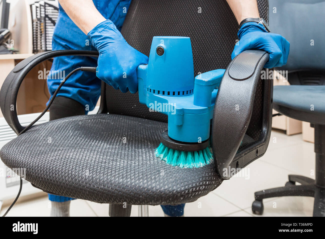 Cleaning service. Young man in workwear and rubber gloves cleans the ...