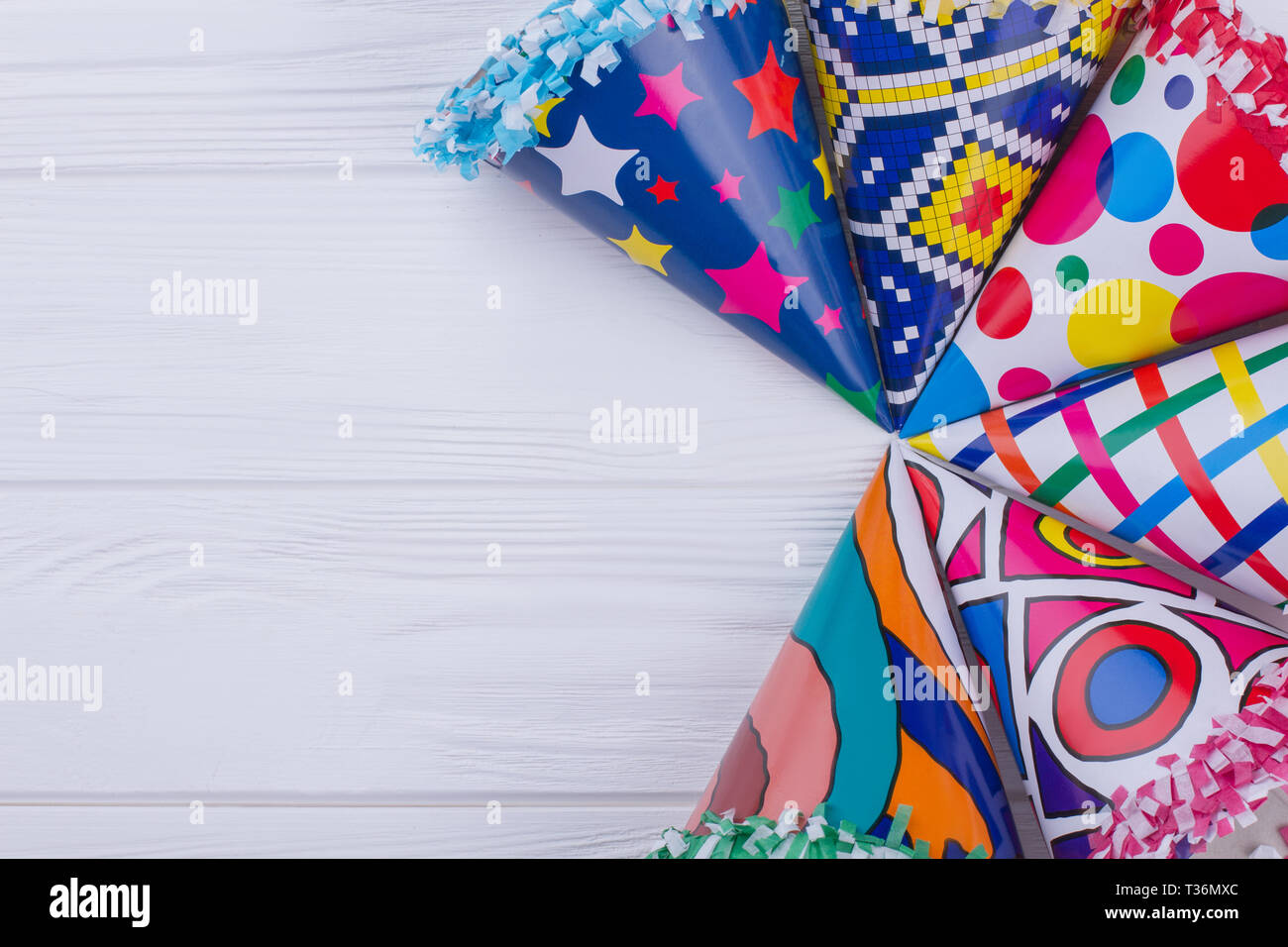 Set of colorful party hats on wooden table. Group of cardboard party ...