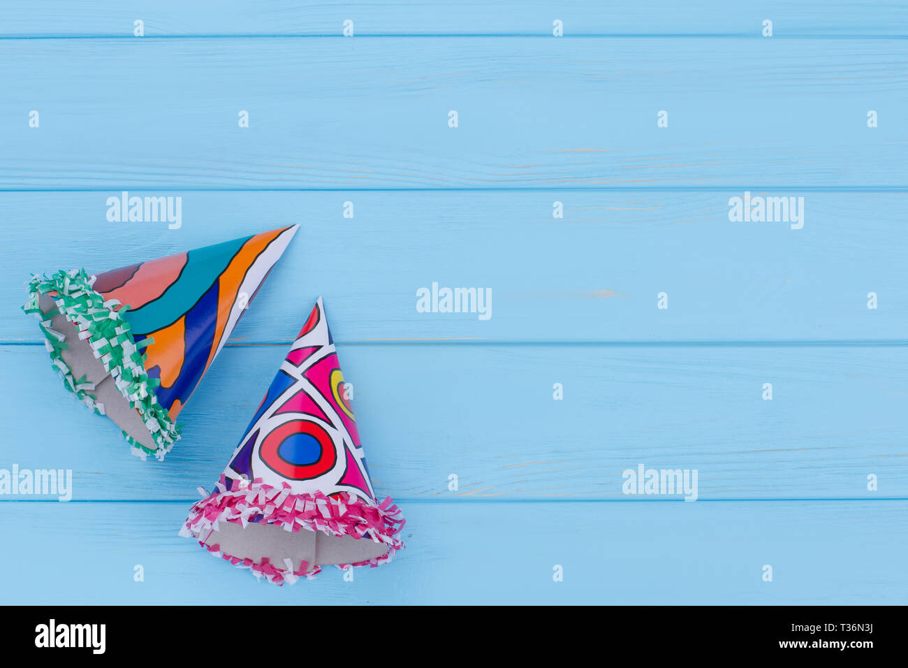 Cone hats for Birthday or carnival party. Party caps on wood table with ...