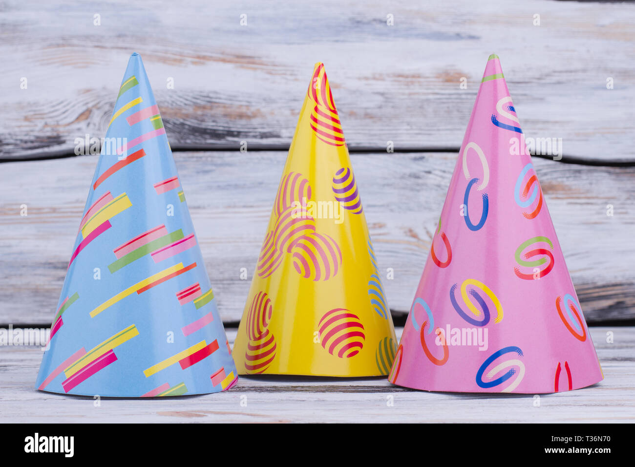 Colored party hats on wooden background. Cardboard caps for Birthday ...