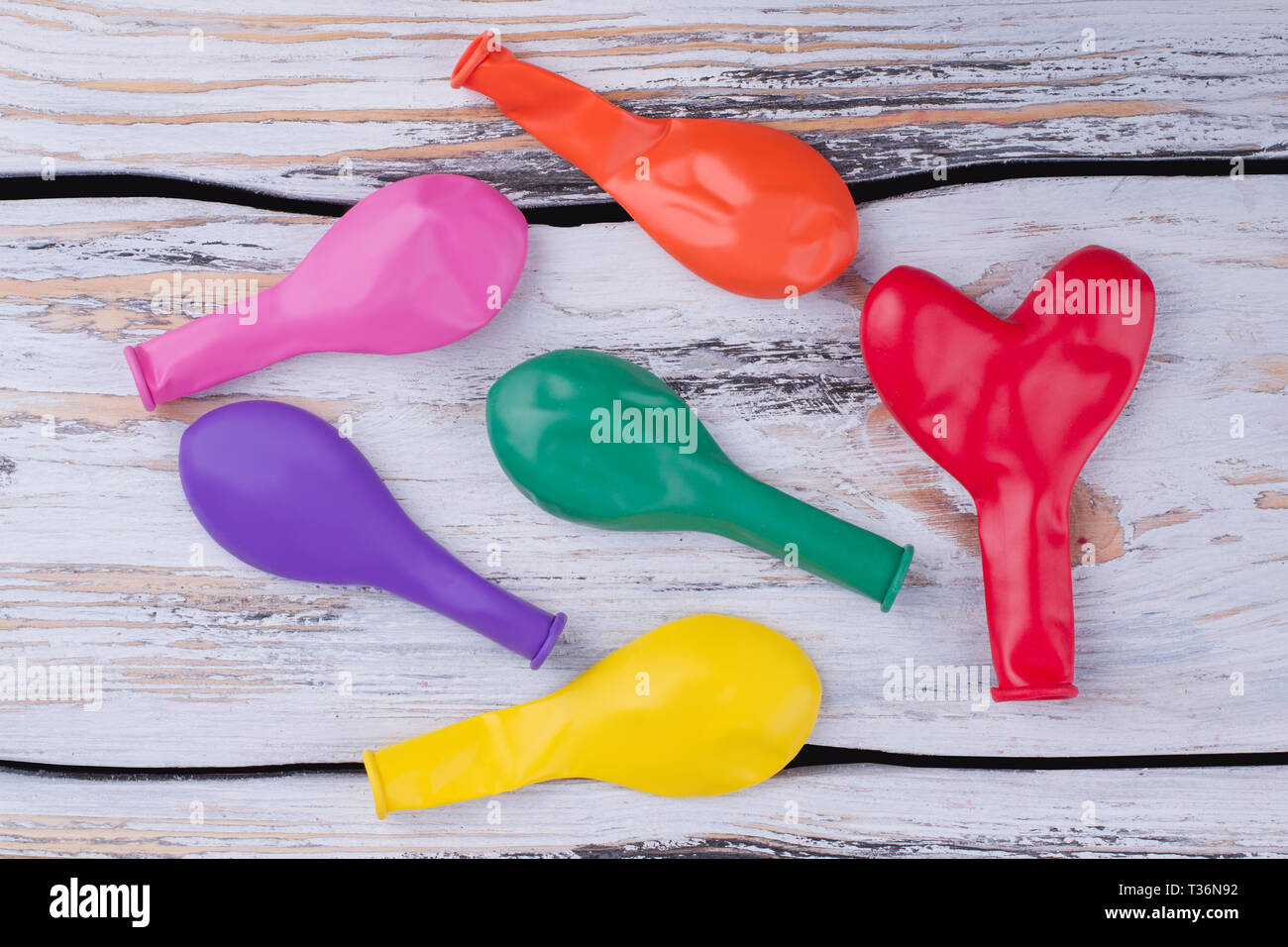 Deflated balloons on wooden boards. Party decoration items Stock Photo ...