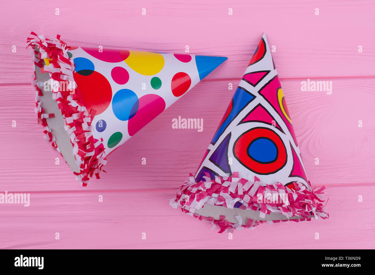 Funny party hats on color background. Decorated party caps on pink ...