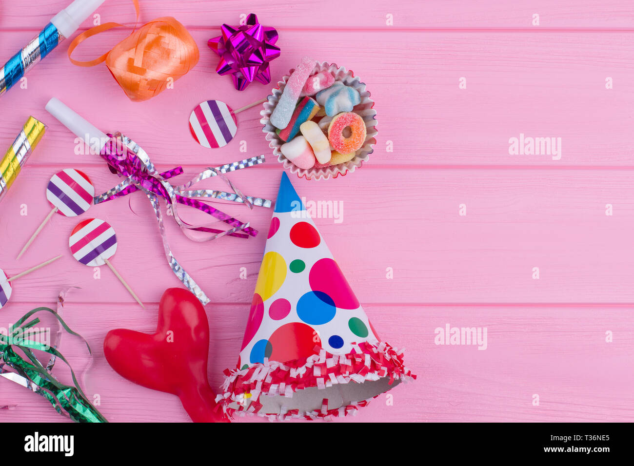 Colorful Birthday party supplies on pink wood. Carnival or Birthday ...