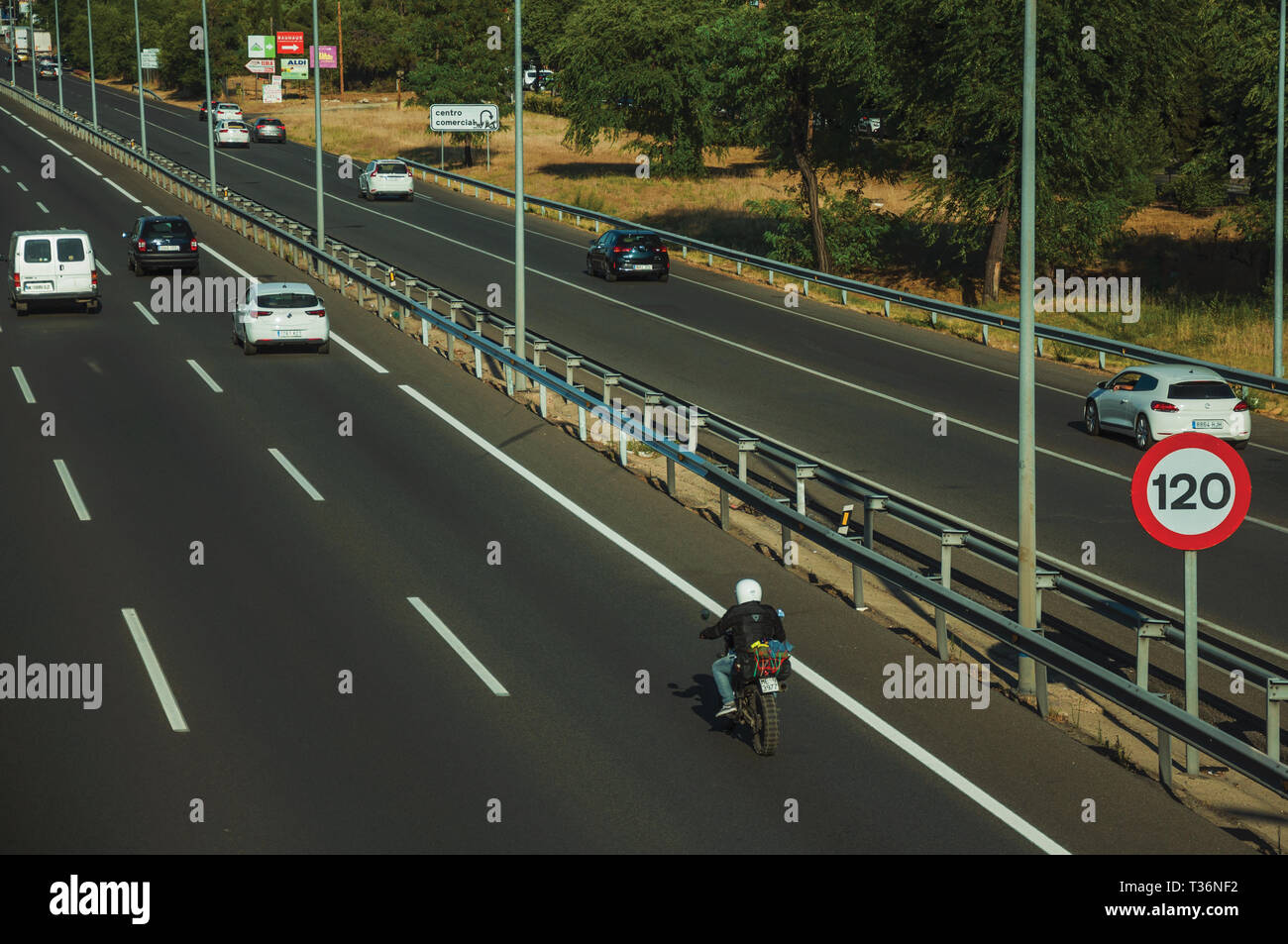 Cars and motorcycle passing through highway and SPEED LIMIT signpost in ...