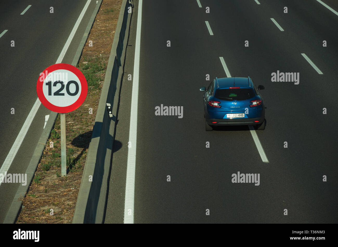 Car passing through highway and SPEED LIMIT signpost, on sunset in ...
