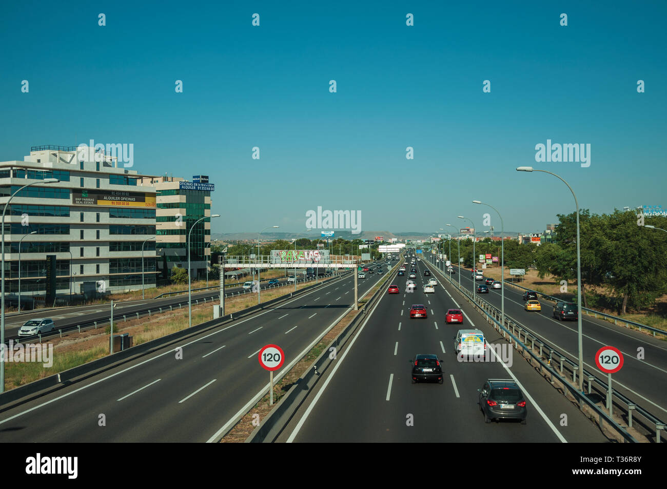 Highway with heavy traffic and SPEED LIMIT signposts at business ...