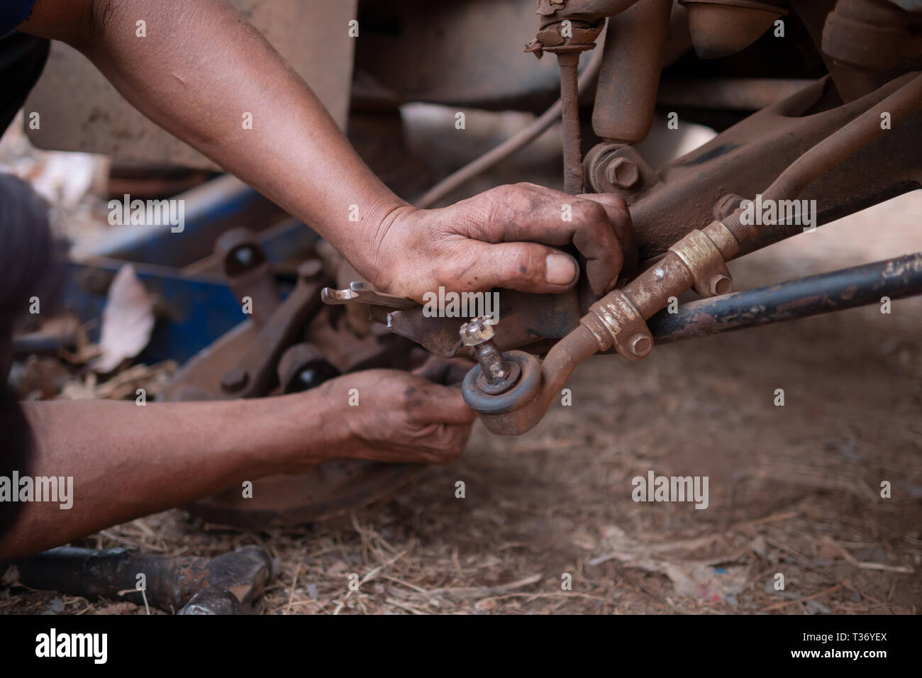Hands of mechanic touching wishbone control arm of the truck to fix and ...