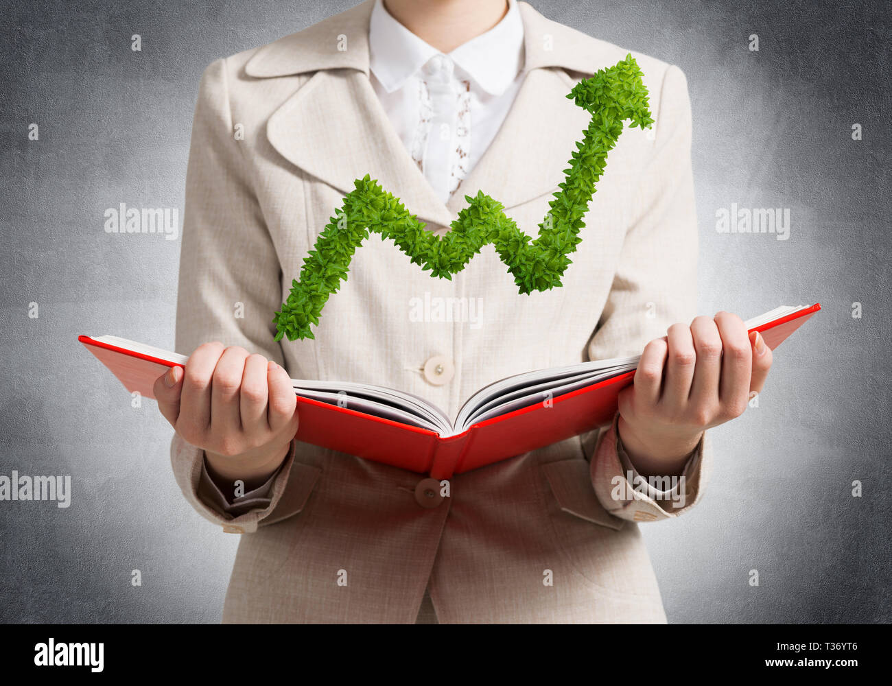 Businesswoman showing green plant in shape of grow up trend above ...