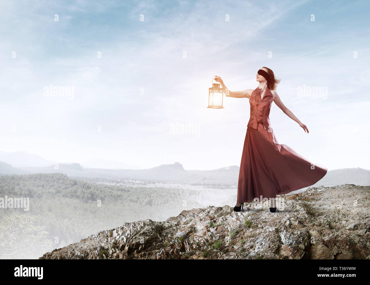 Young woman wearing blindfold with lantern at natural landscape Stock ...