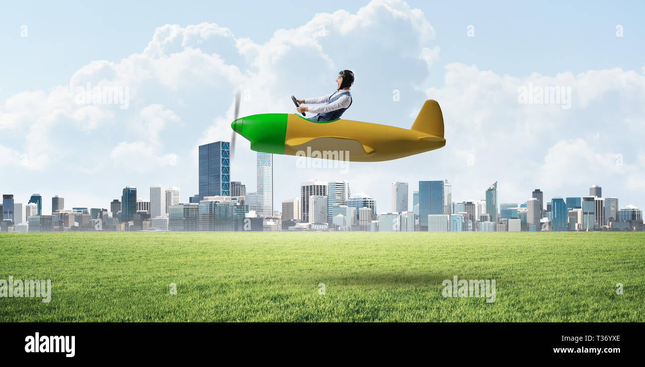 Businessman in aviator hat and goggles driving propeller plane ...