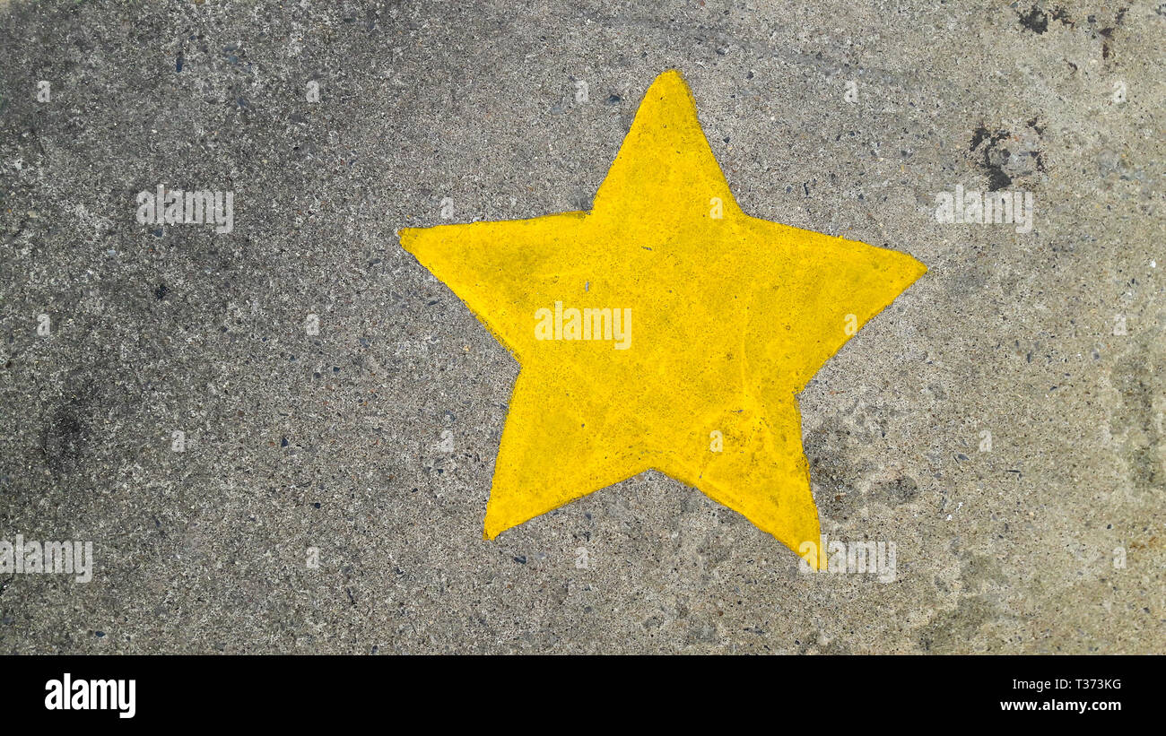 Yellow painting star on concrete texture background Stock Photo - Alamy