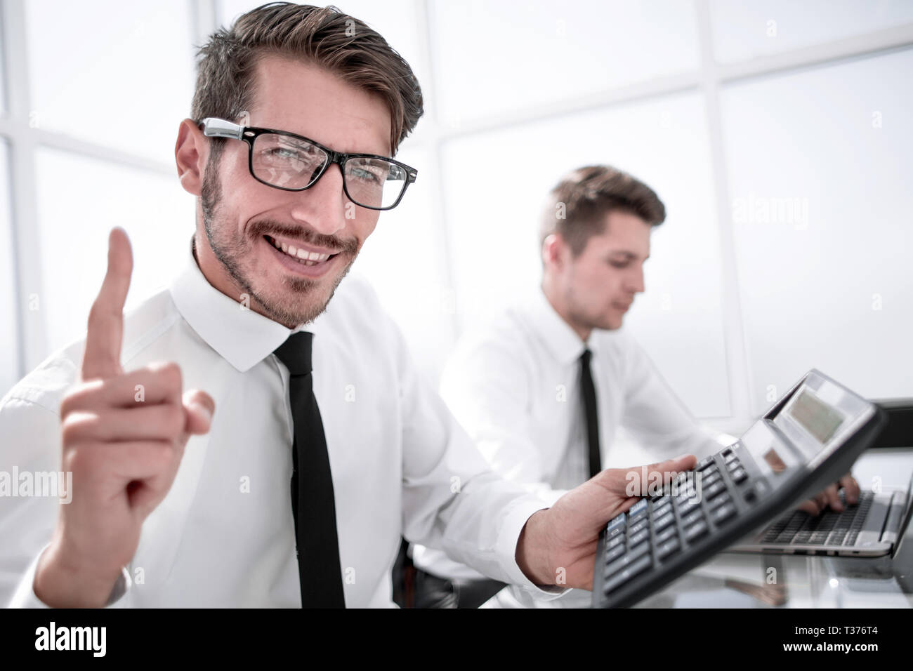 young accountant holding a thumb up and smiling Stock Photo - Alamy