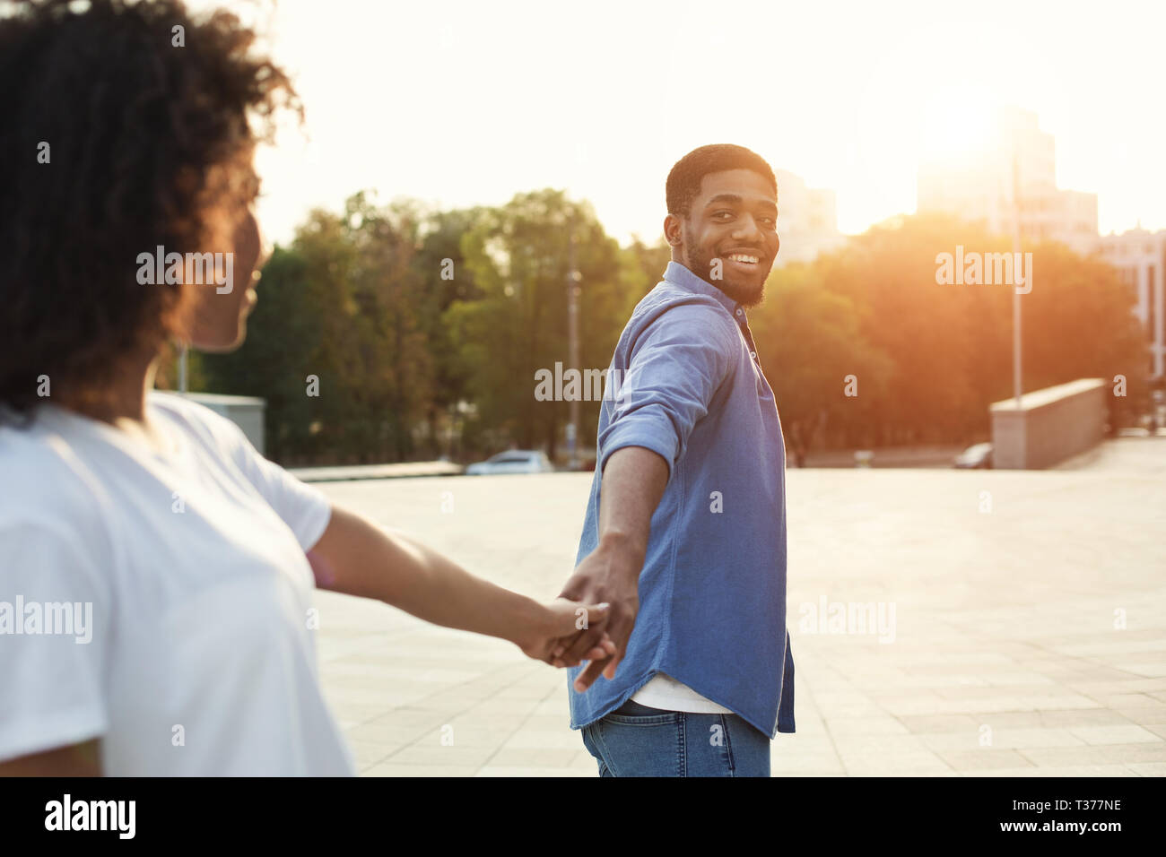 Follow me. Girlfriend following boyfriend holding hands Stock Photo - Alamy