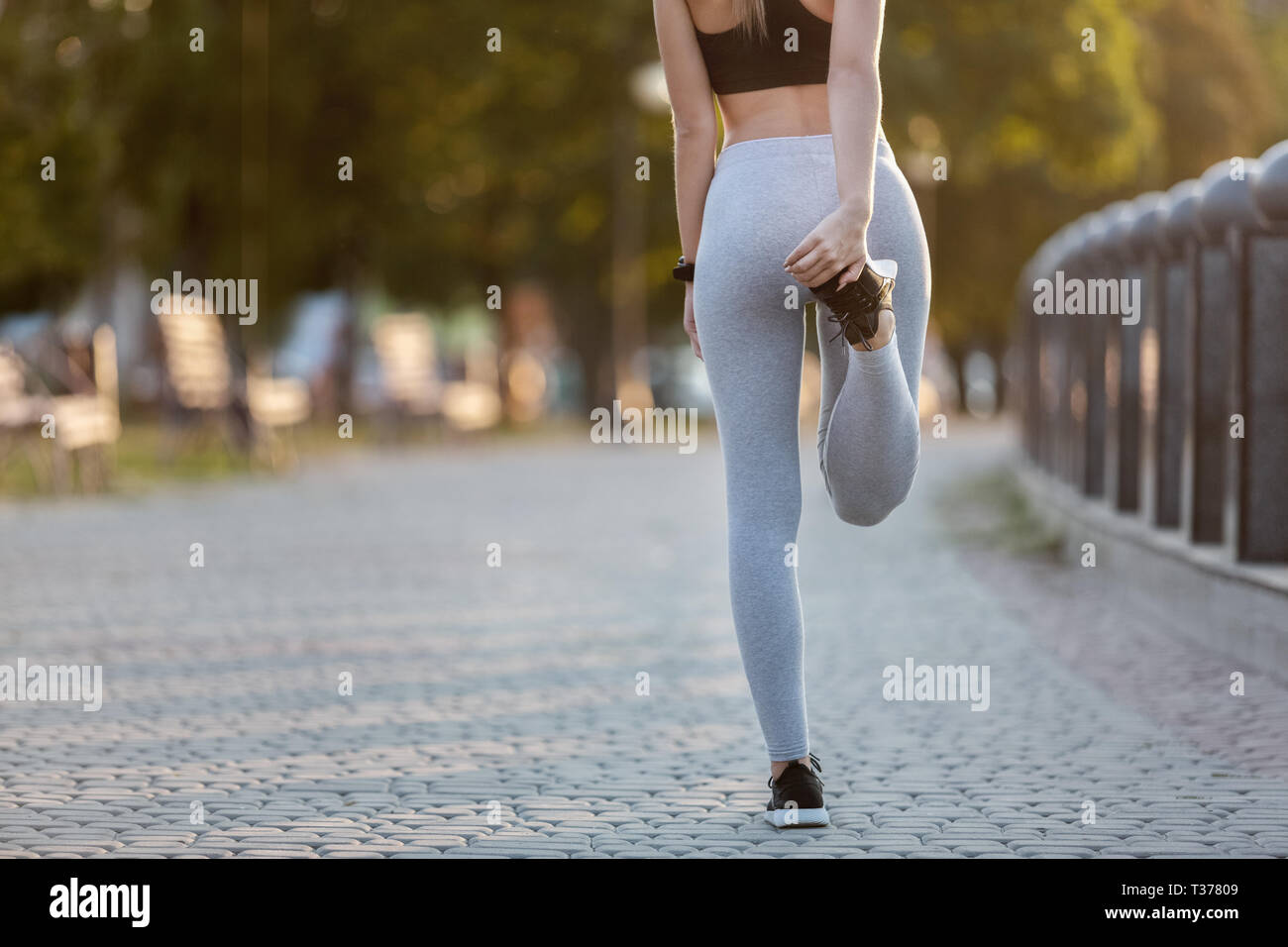 Fitness woman runner stretching legs before run Stock Photo - Alamy