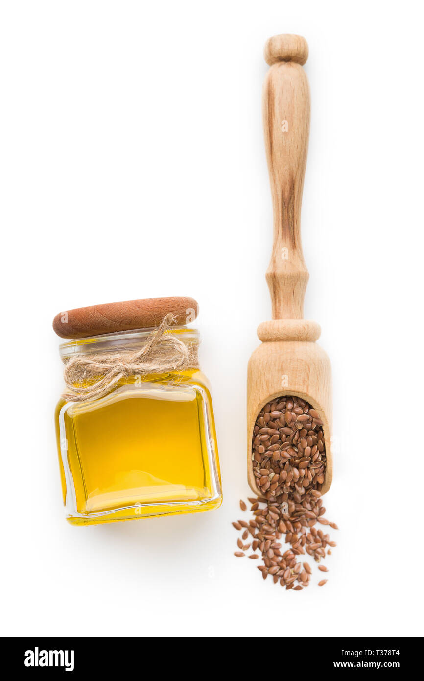 Linseed oil in bottle and scoop with linseeds isolated on white ...