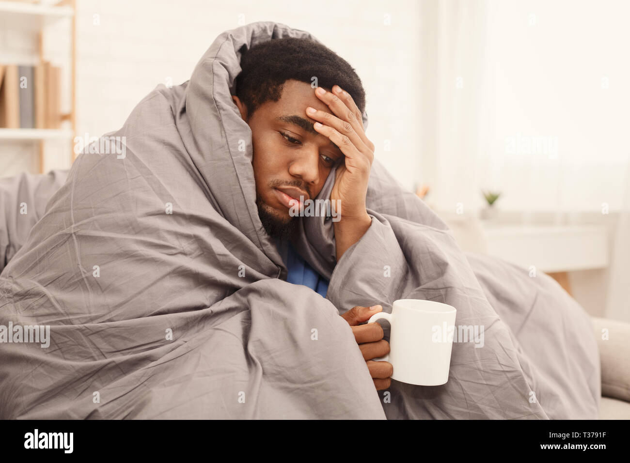 Sick male wrapped in blanket hi-res stock photography and images - Alamy