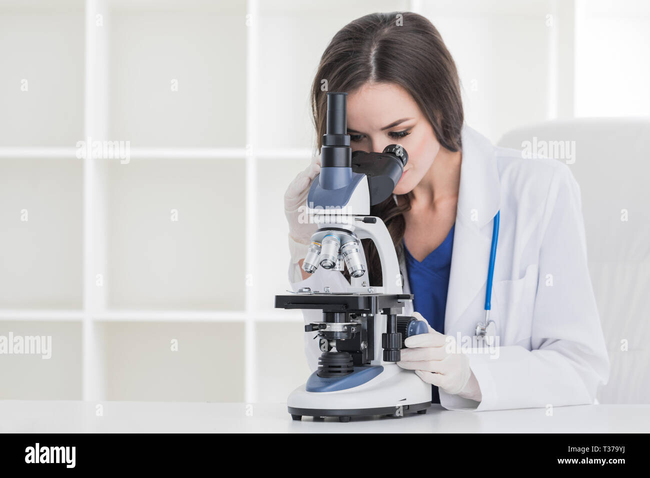 Young scientist with microscope in a laboratory doing some research ...