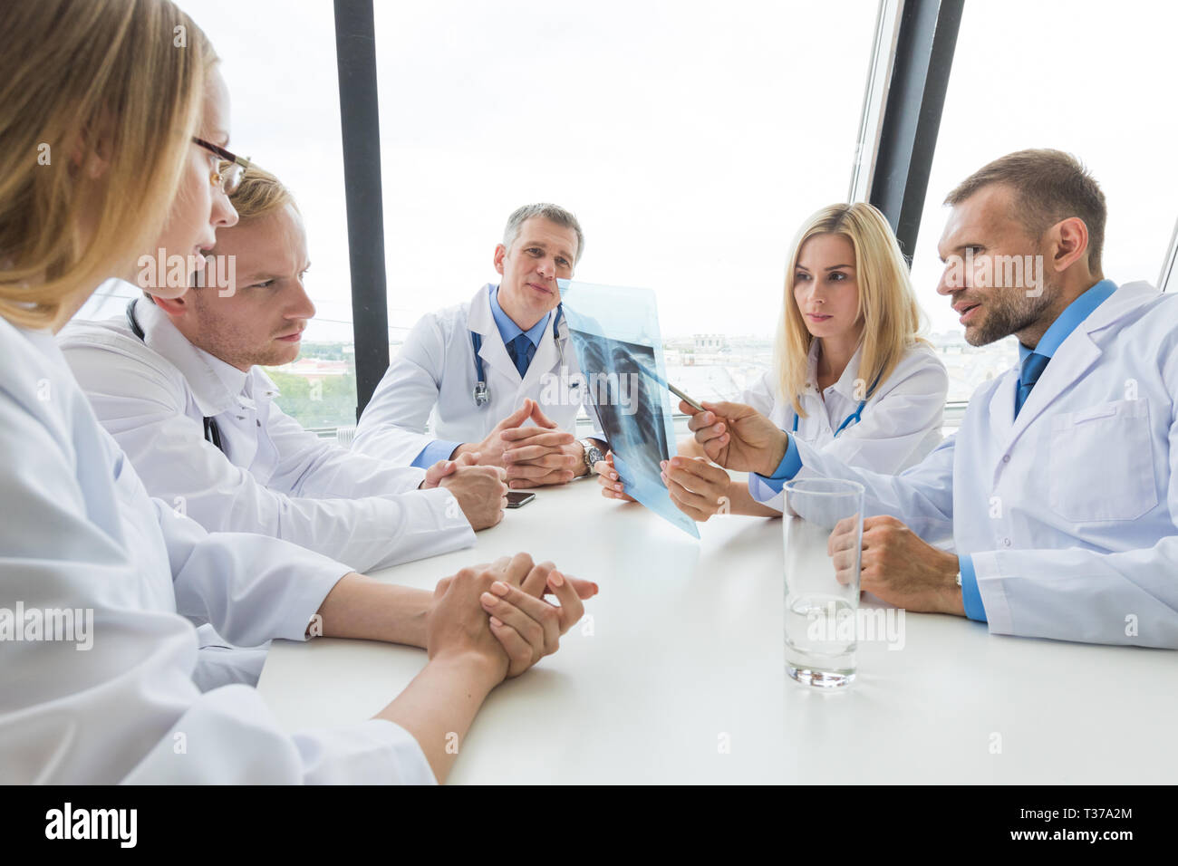 medical colleagues discuss x-ray sitting at the office table Stock ...