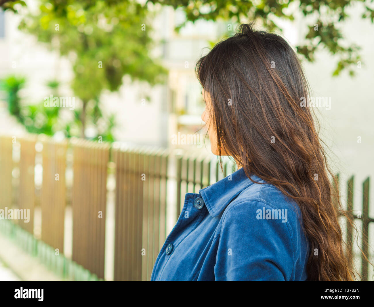 Authentic young woman outdoors turned with her back. Urban scene Stock ...