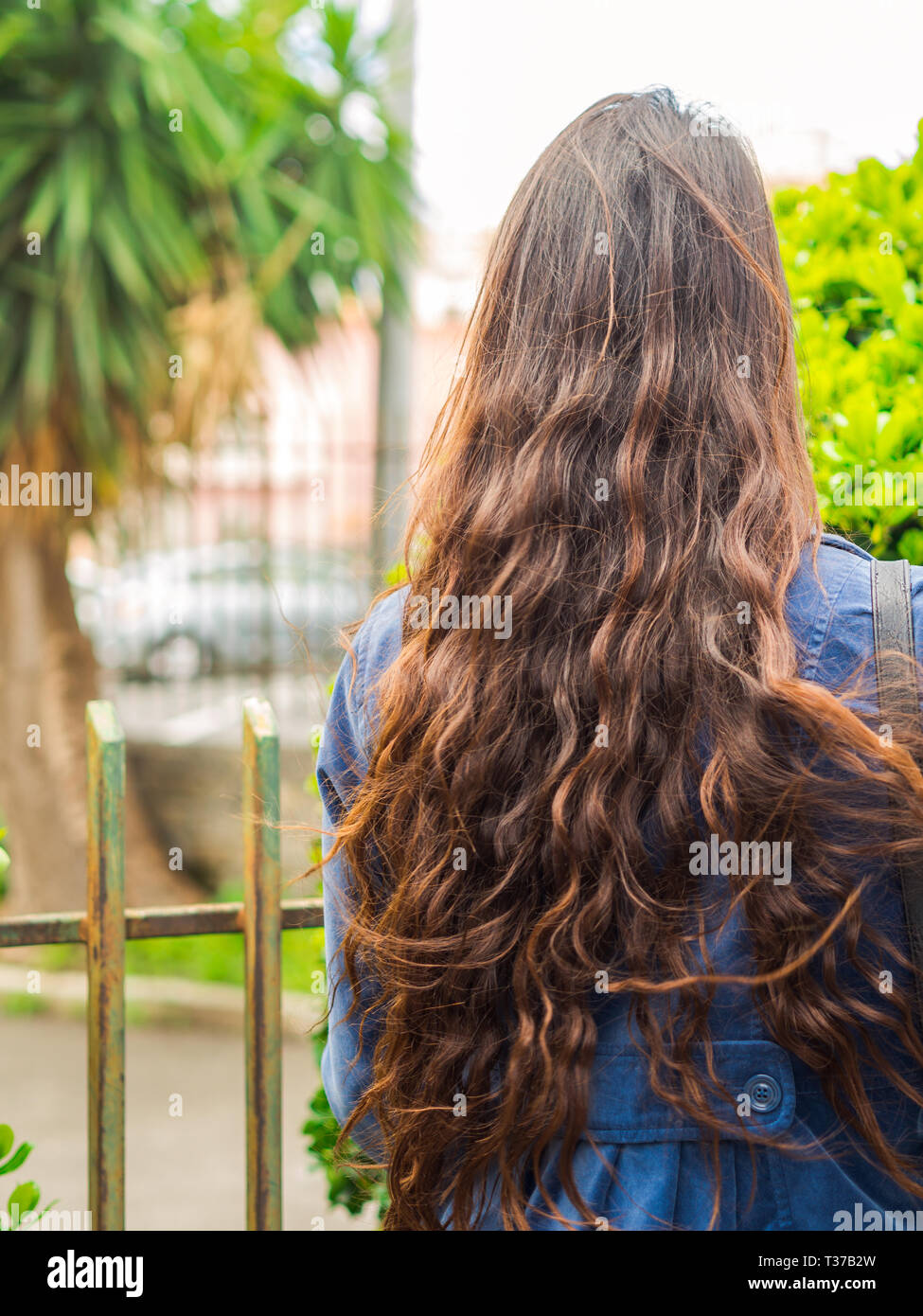 Authentic young woman outdoors turned with her back. Urban scene Stock ...