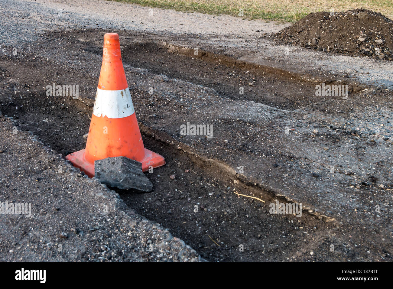 White orange traffic hazard cone on asphalt road repair Stock Photo - Alamy
