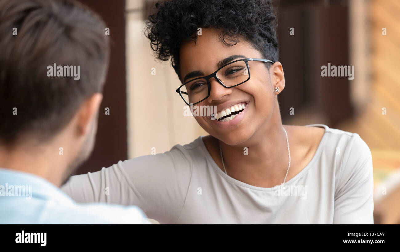 Happy african woman and caucasian boyfriend laugh on first date Stock ...