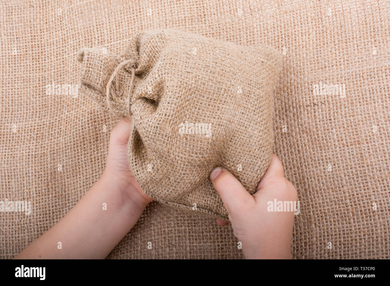 Hand holding an empty little sack made of linen Stock Photo - Alamy