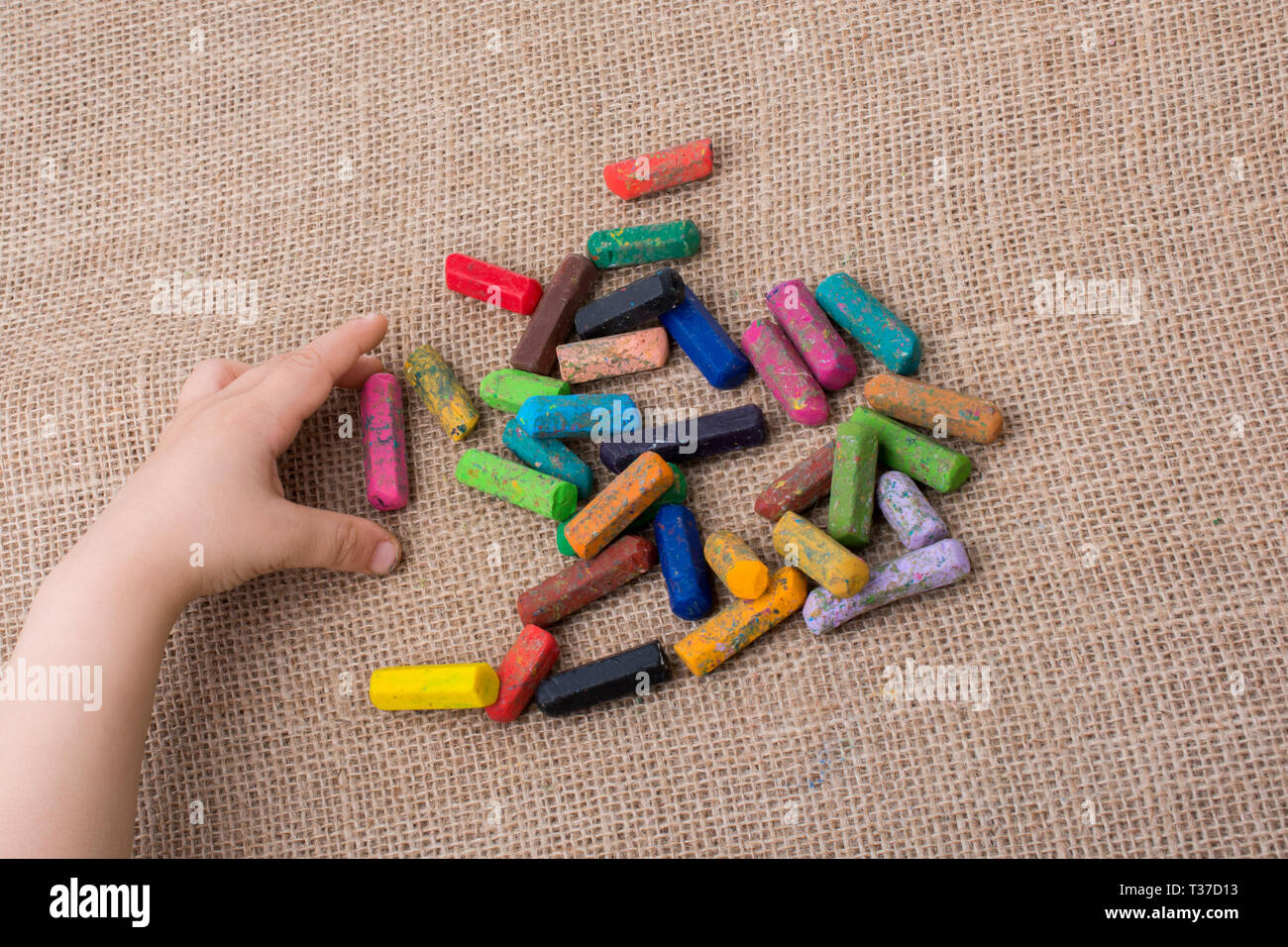 Used color crayons and a toddlers hand holding one Stock Photo - Alamy